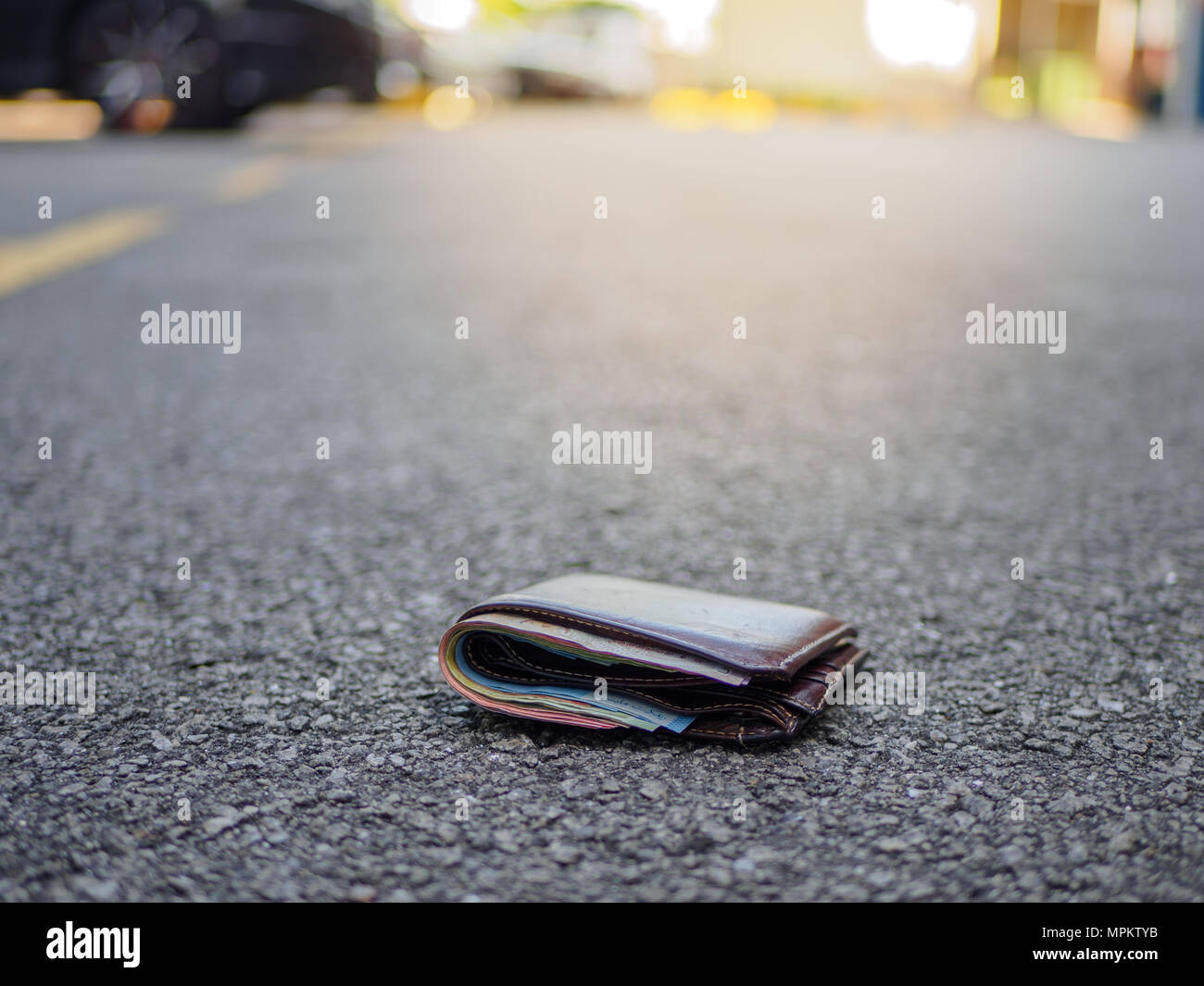 wallet with money drop on the street, lost money concept, copy space on ...