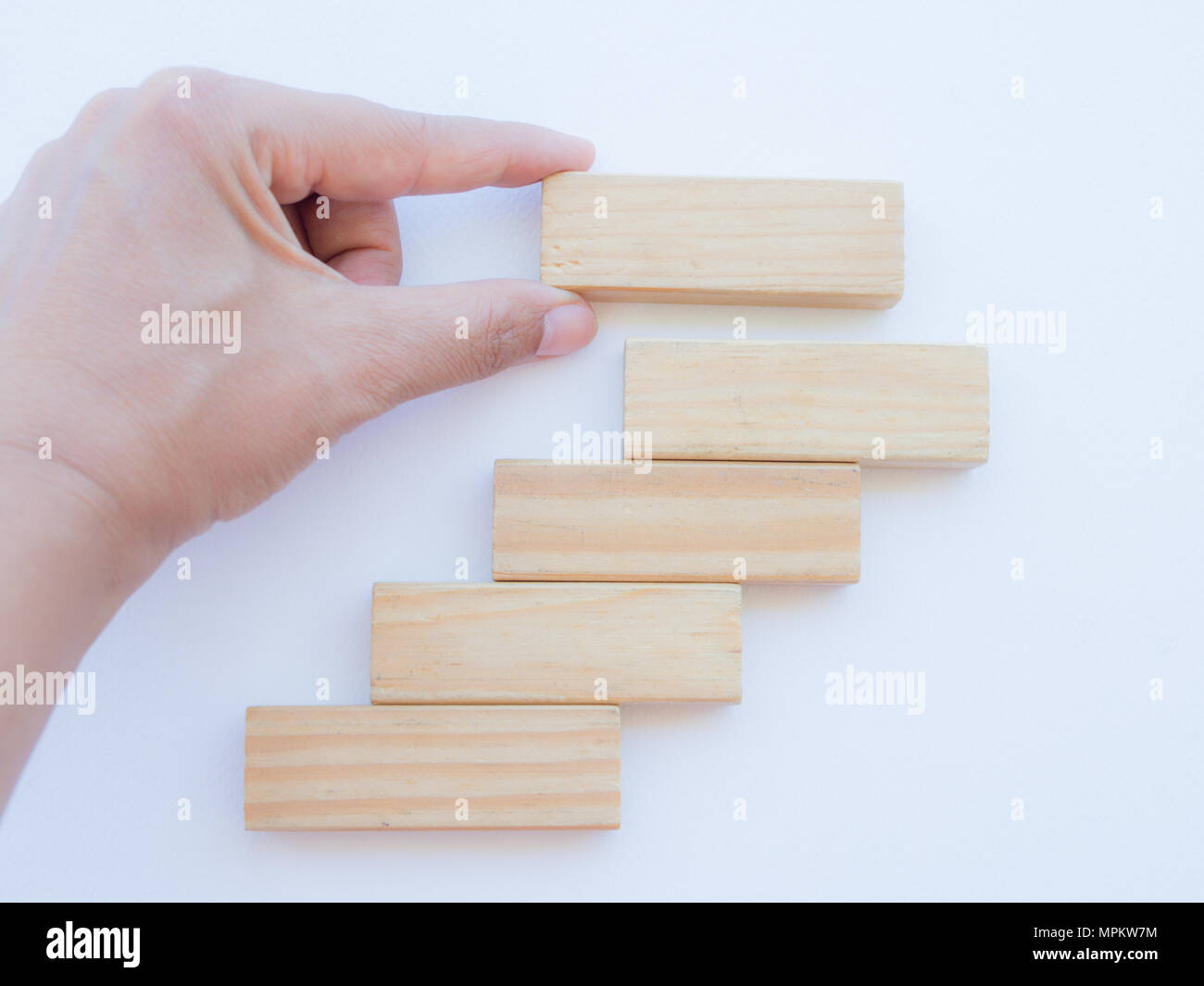 Concept of building success foundation. Women hand put wooden blocks in ...