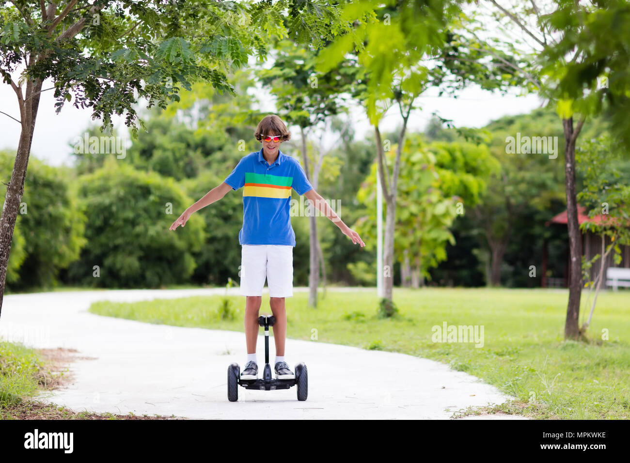 Child on hover board. Kids riding scooter in summer park. Balance board ...