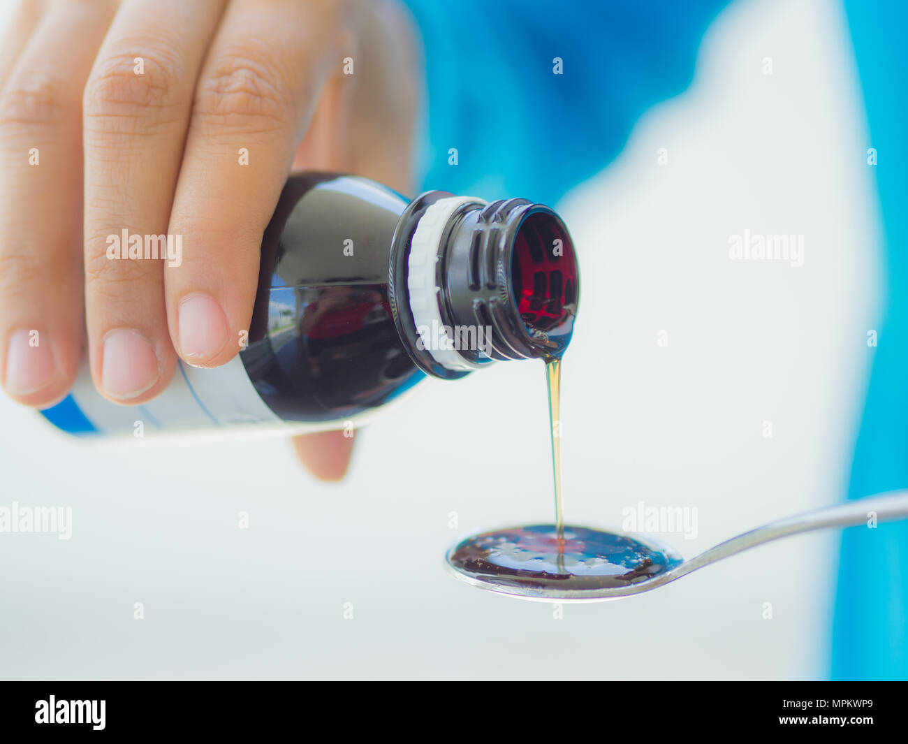 healthcare, people and medicine concept - woman pouring medication or ...