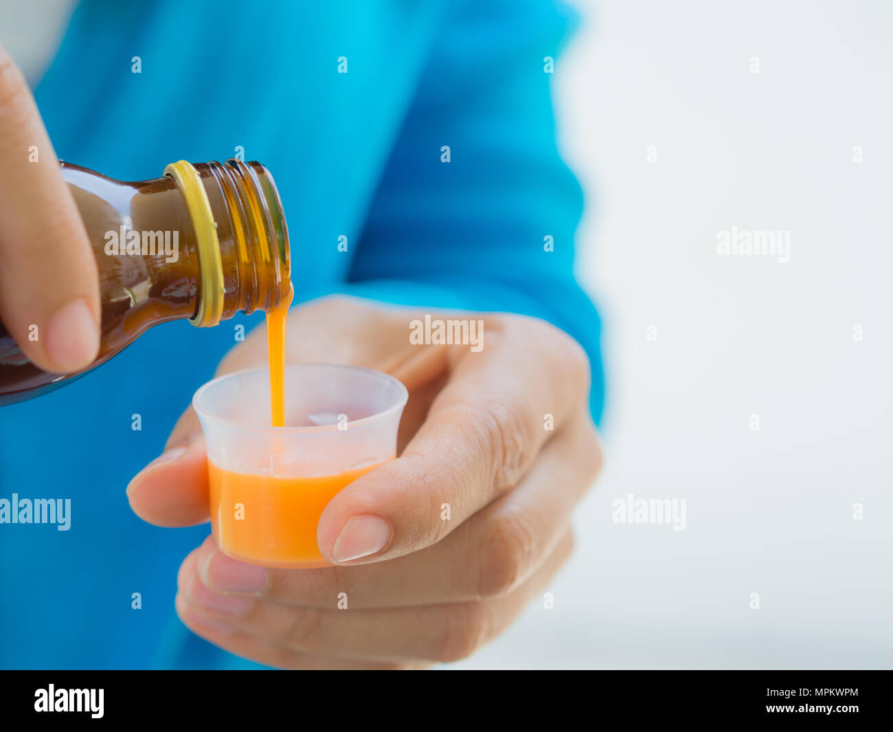 healthcare, people and medicine concept - woman pouring medication or ...