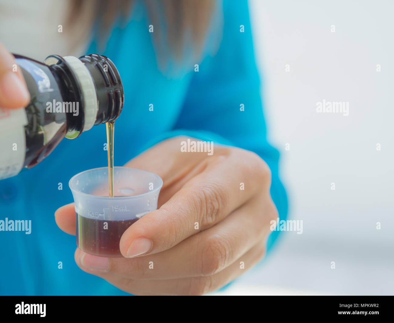 healthcare, people and medicine concept - woman pouring medication or ...