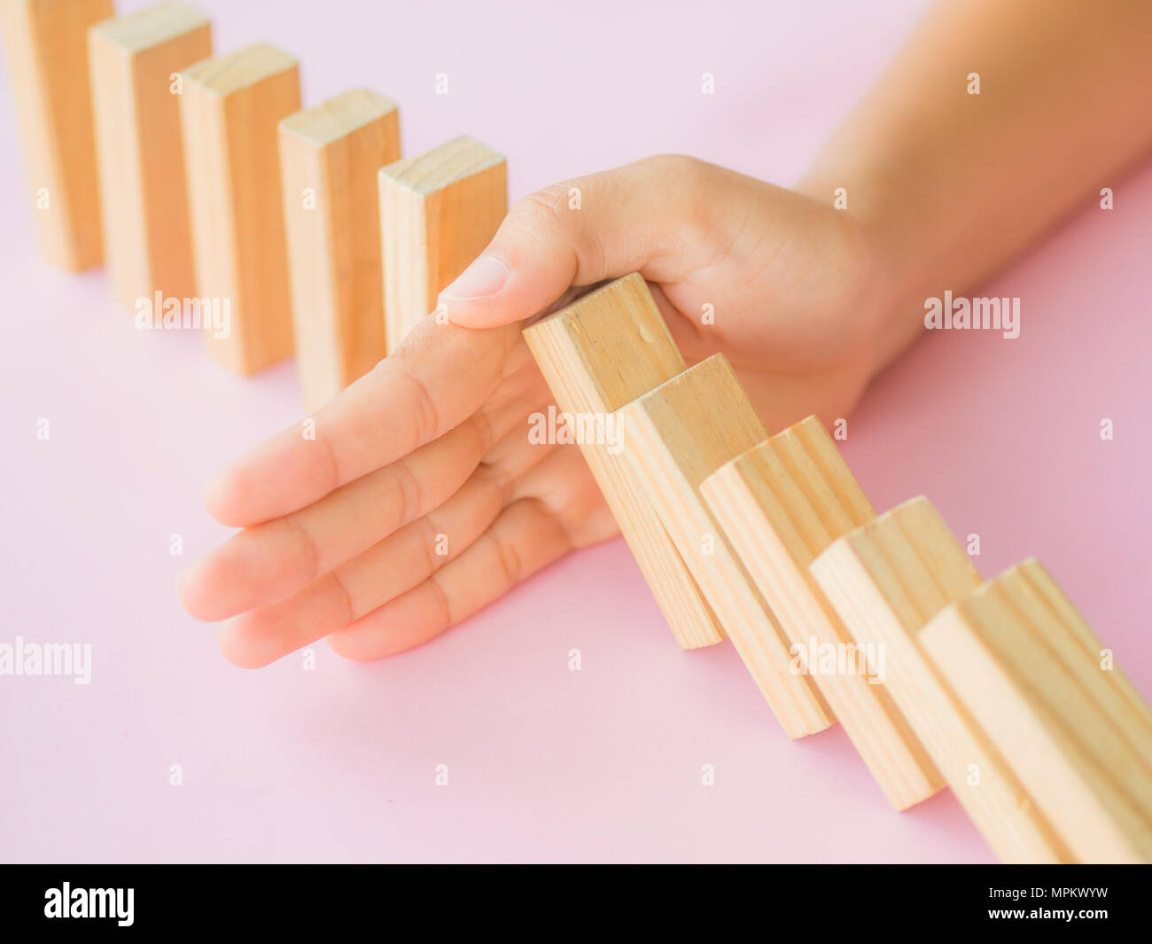 Solution concept with hand stopping wooden blocks from falling in the line of domino Stock Photo ...
