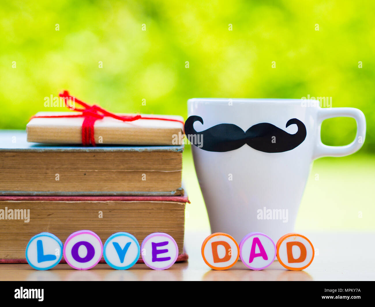 Father's day concept. LOVE DAD alphabet on stack of books, gifts, tea ...