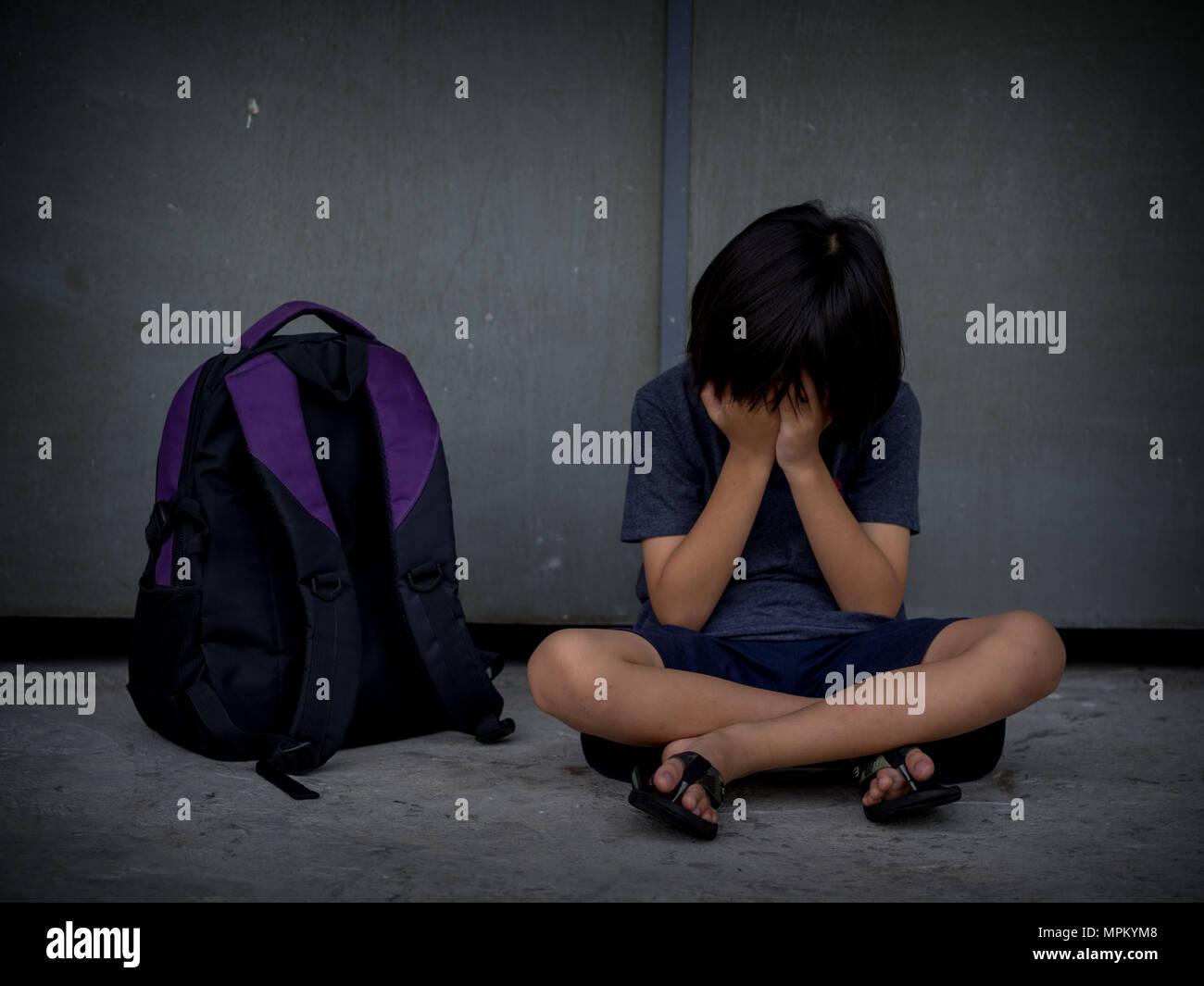 Retro picture with grain. Sad child sitting on the floor with school ...