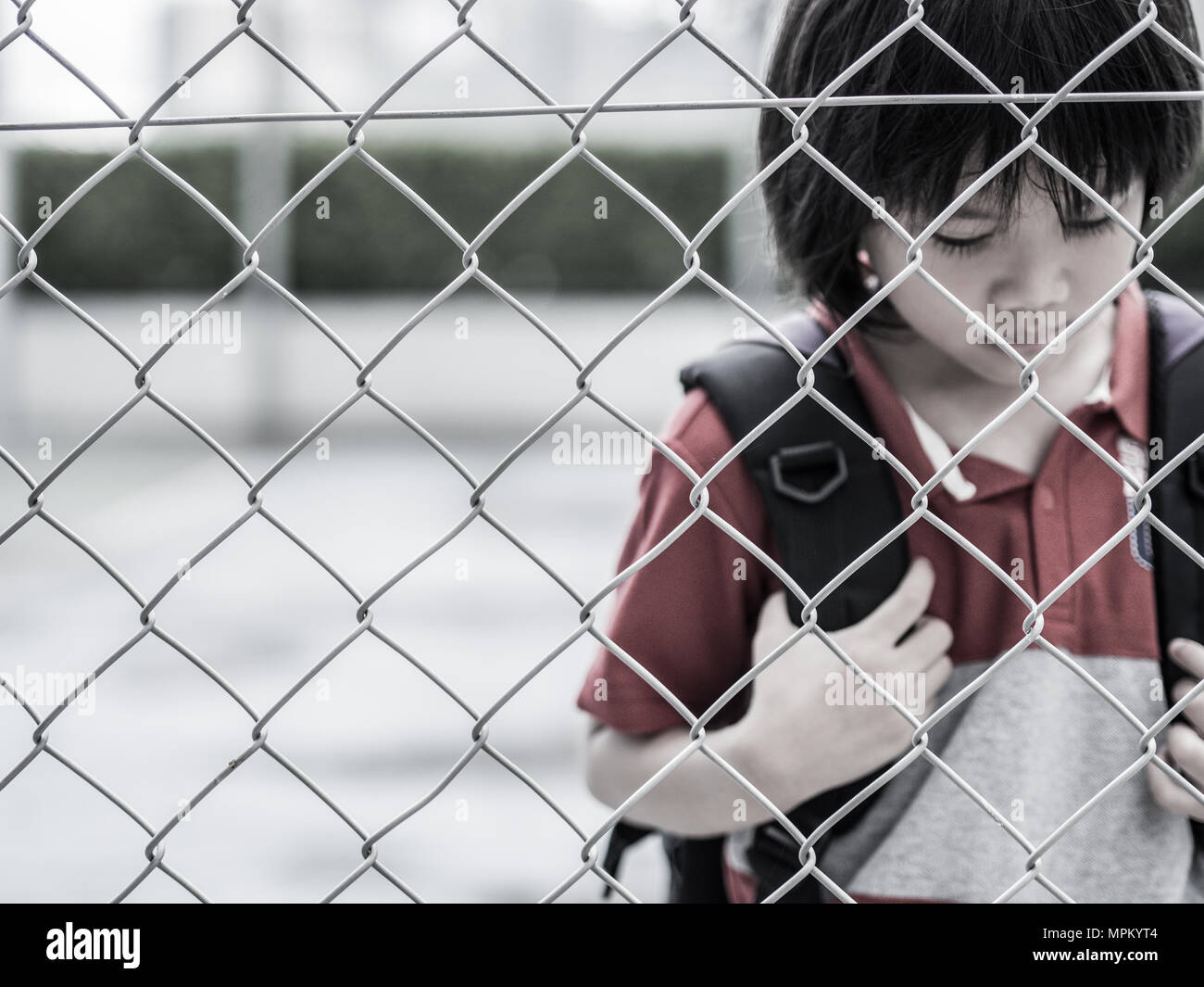 Portrait of handsome sad boy behind fence mesh netting. Emotions ...