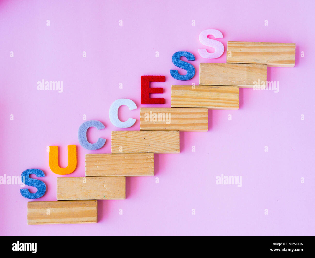 Wood block stacking as step stair with colorful of "SUCCESS" word on it ...