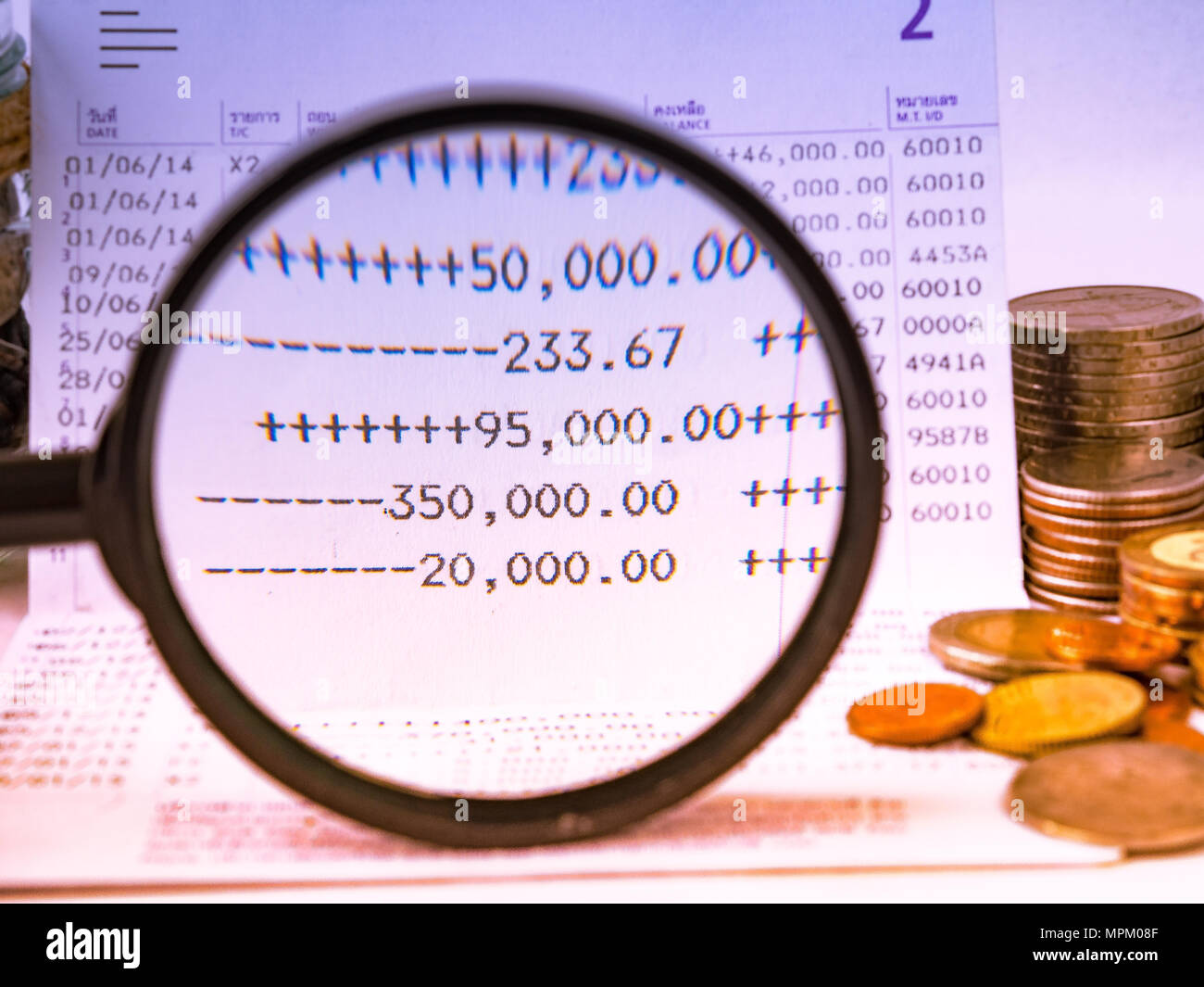 Magnifying glass on financial statement and stack of coins Stock Photo ...