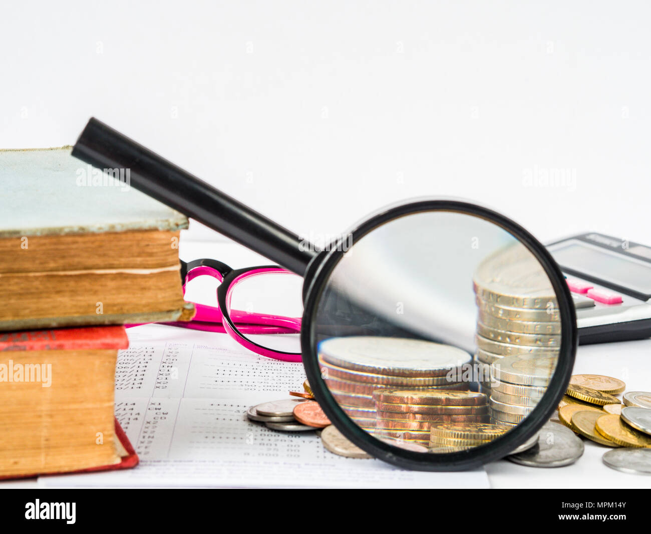 Magnifying glass on financial statement and stack of coins Stock Photo ...