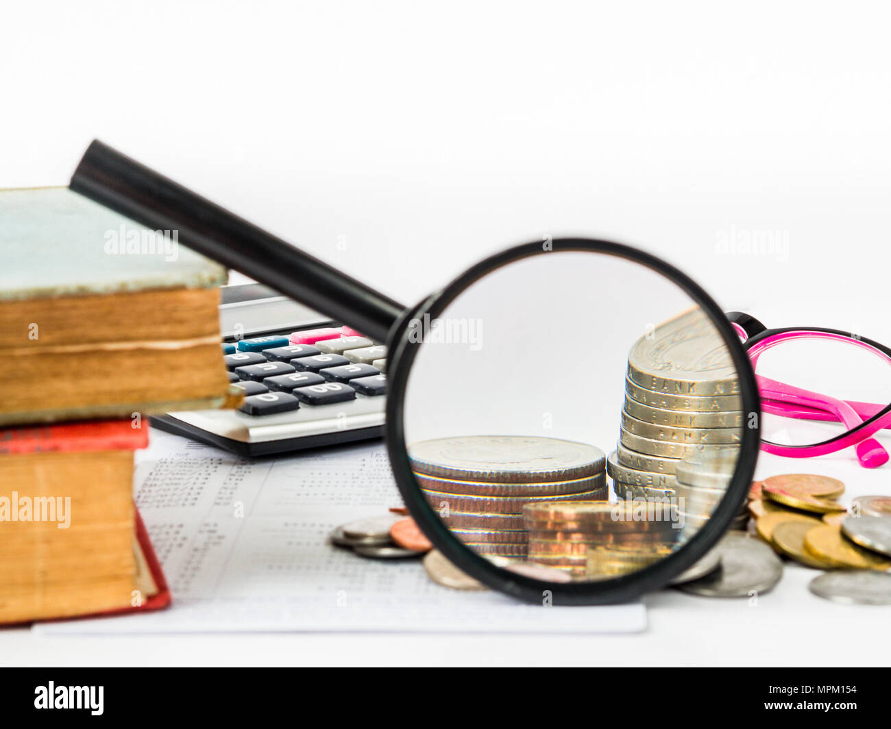 Magnifying glass on financial statement and stack of coins Stock Photo ...