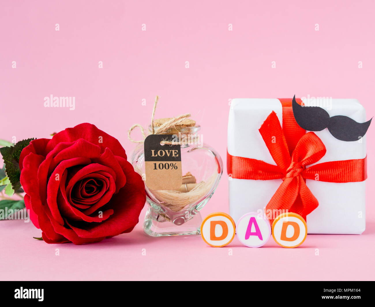 Father's day concept. DAD message with red rose and gift on yellow ...