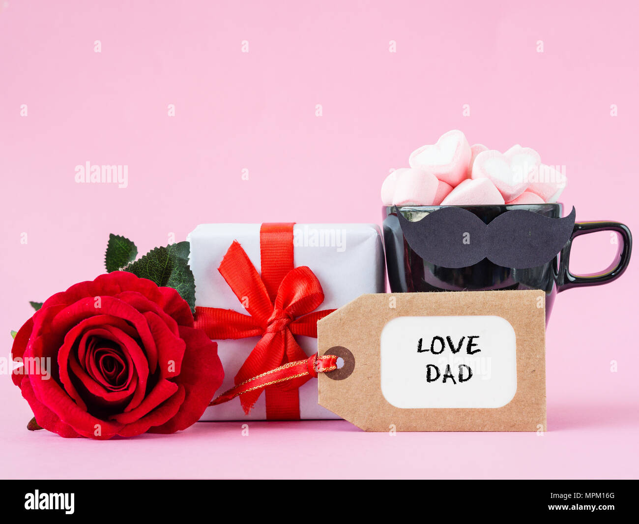 Father's day concept. LOVE DAD message with red rose on pink background ...