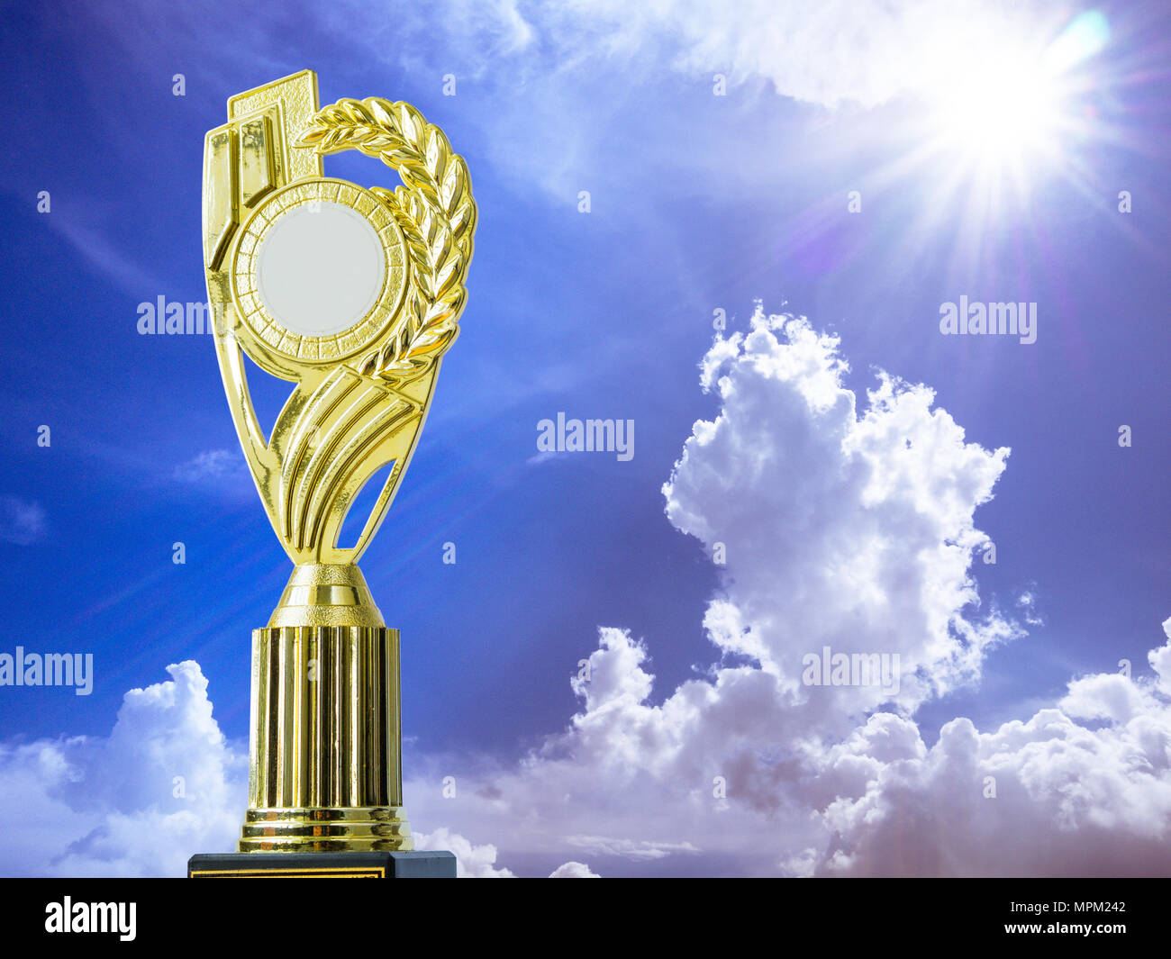 Golden award winning trophy on blue sky and sun background Stock Photo ...