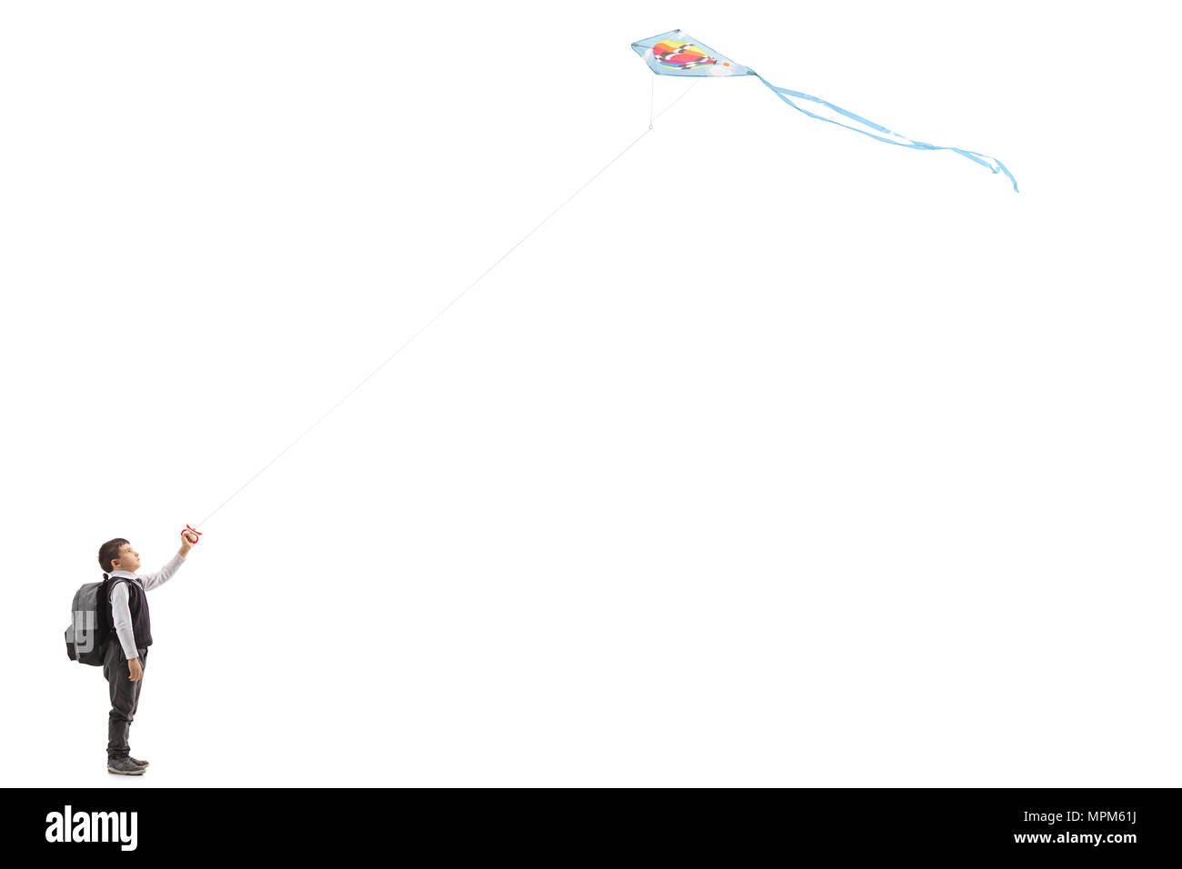Full length profile shot of a little schoolboy flying a kite isolated ...