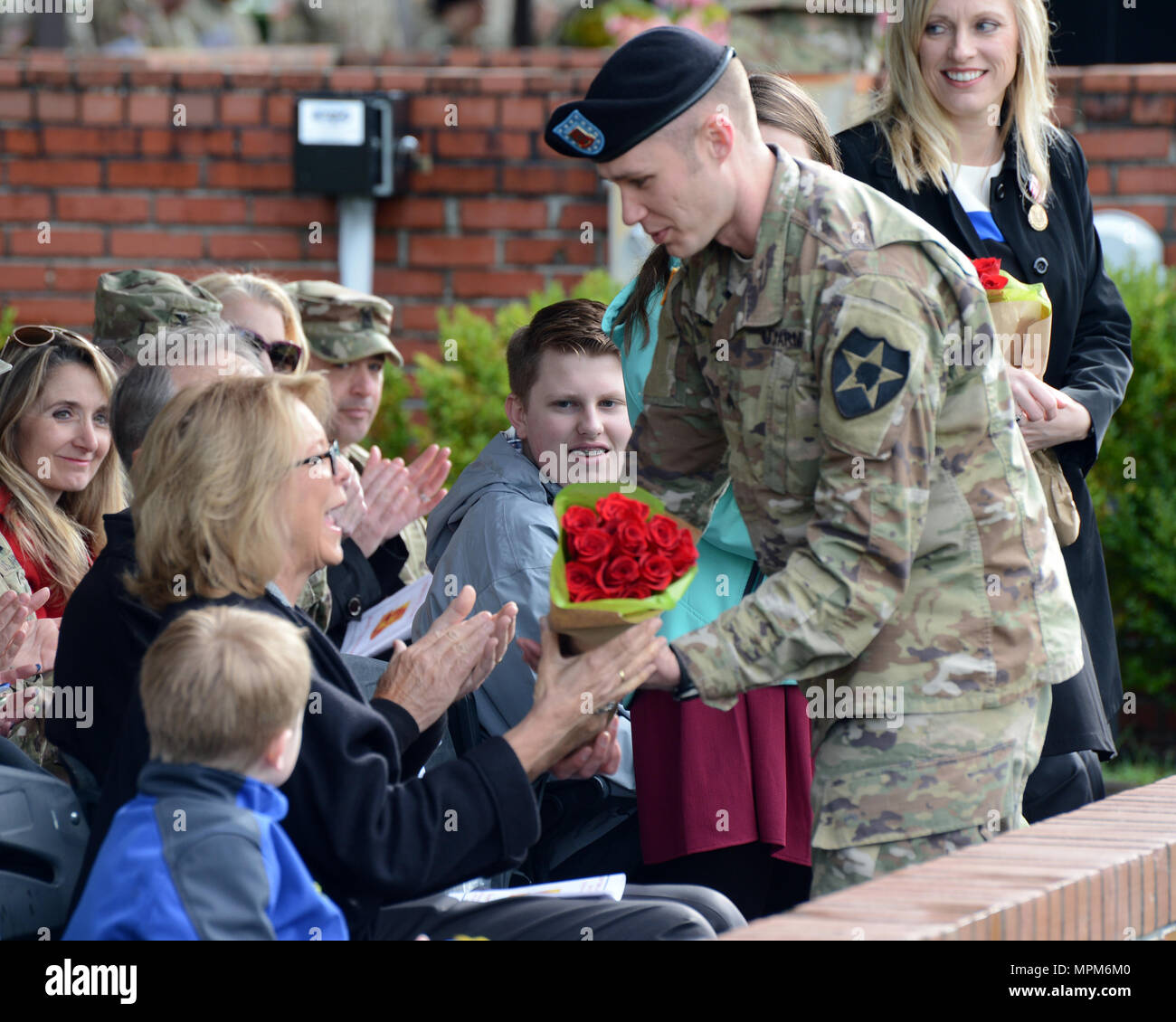 Sgt Brian Lehfeld, HHC, 296th Brigade Support Battalion, hands flowers ...