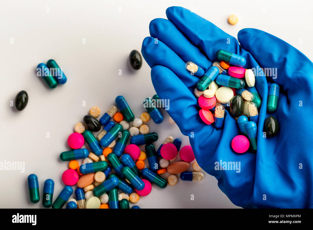 Hands full of medication with different types and colours. Medical ...