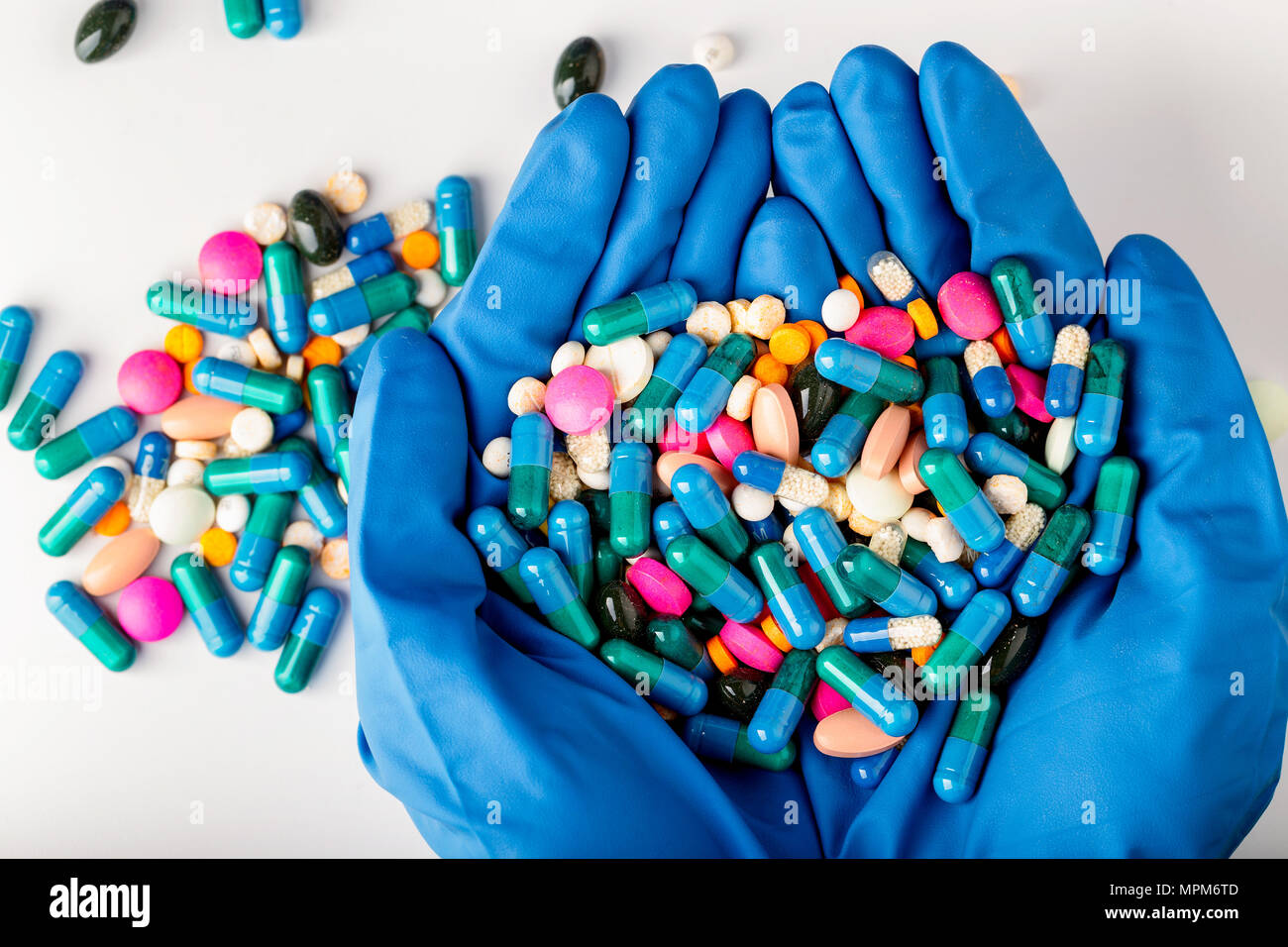 Hands full of medication with different types and colours. Medical ...
