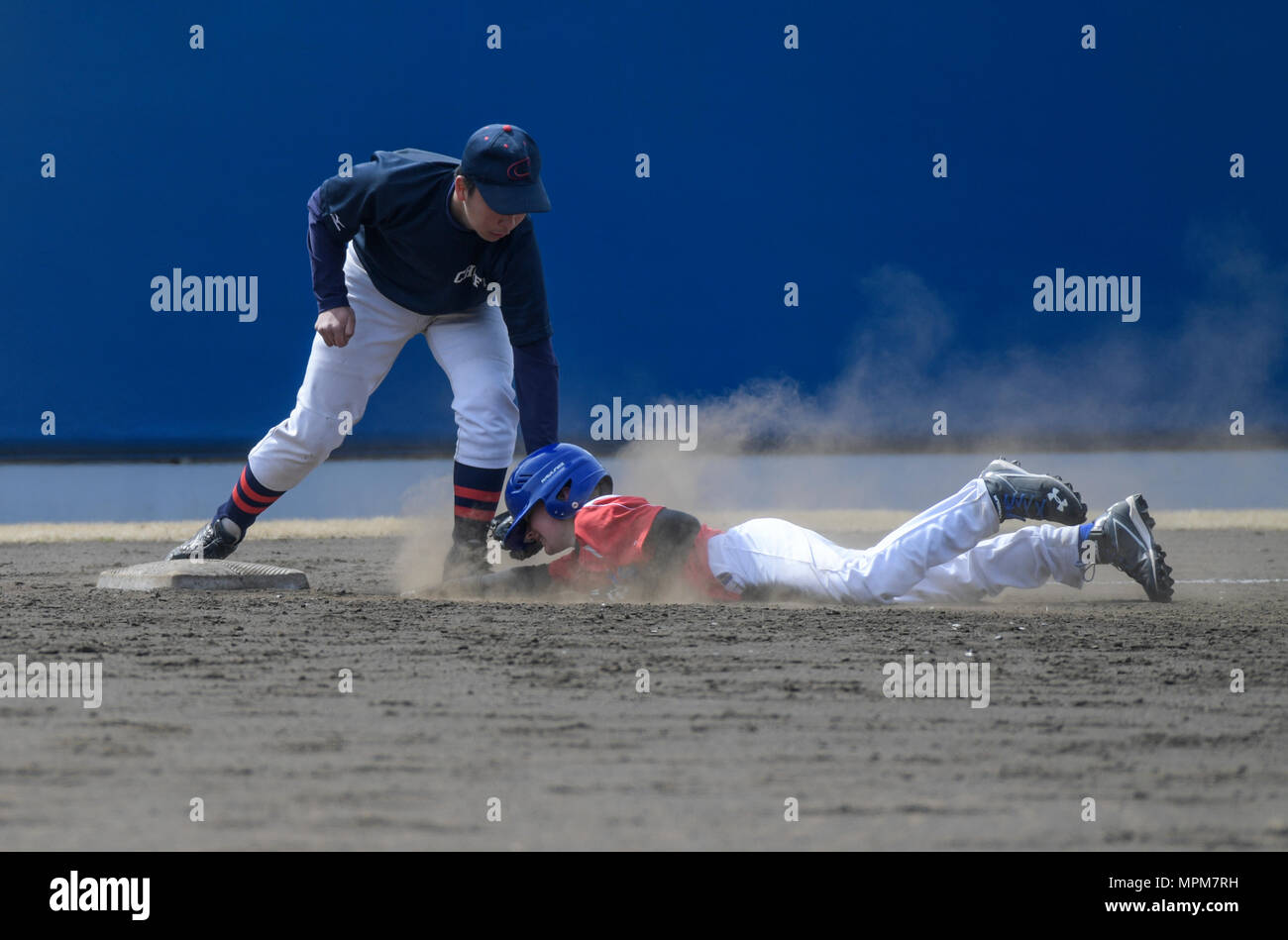 A player from the Yokota Samurai baseball team is tagged out while ...