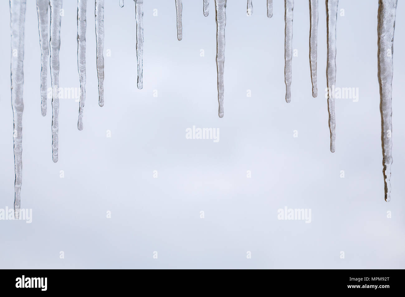 Frozen icicles hanging with sky background and copy space. Icicles in ...