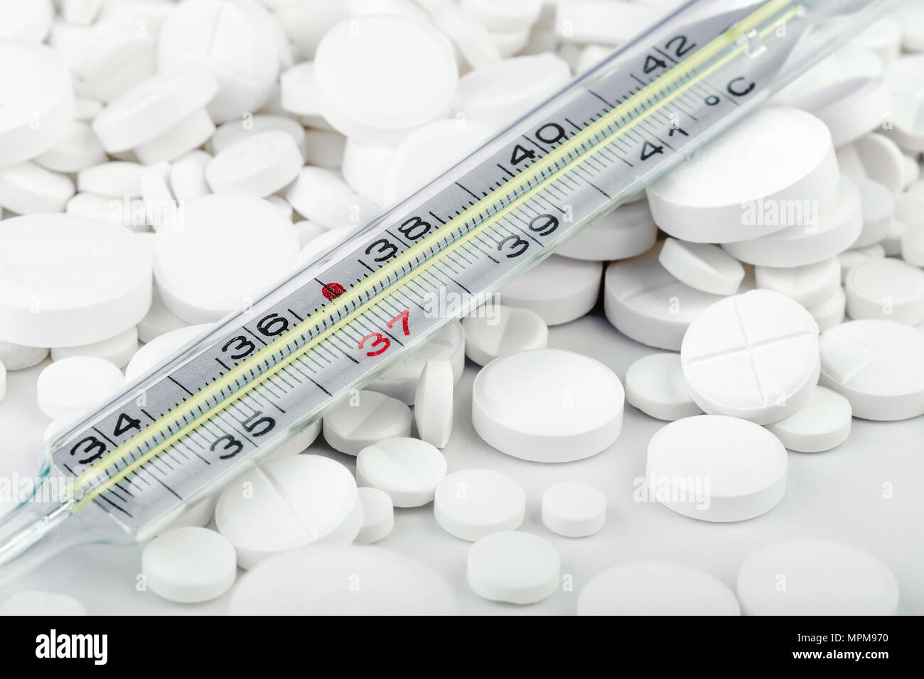 Bunch of white tablets with thermometer. Scattered pills. Selective ...