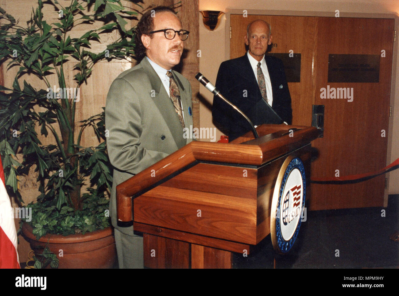 man standing at podium speaking Stock Photo - Alamy