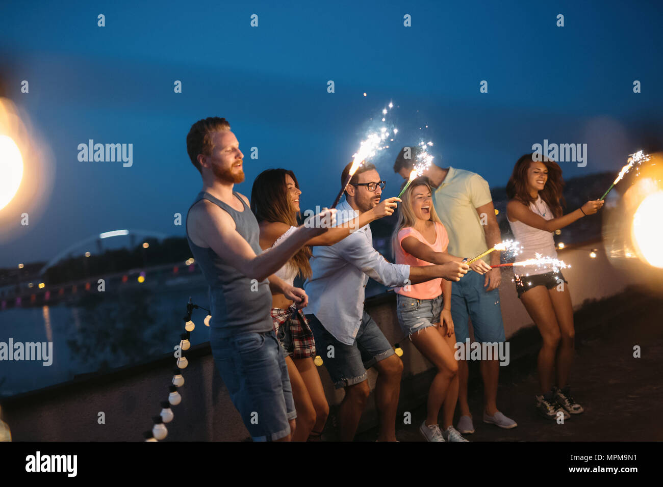 Happy friends lighting sparklers and enjoying freedom Stock Photo - Alamy