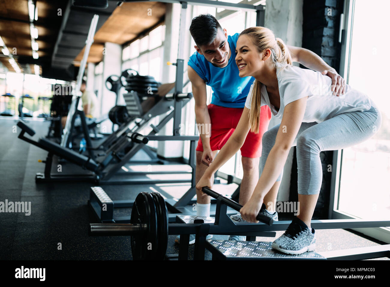 Personal trainer giving instructions to student in gym Stock Photo - Alamy