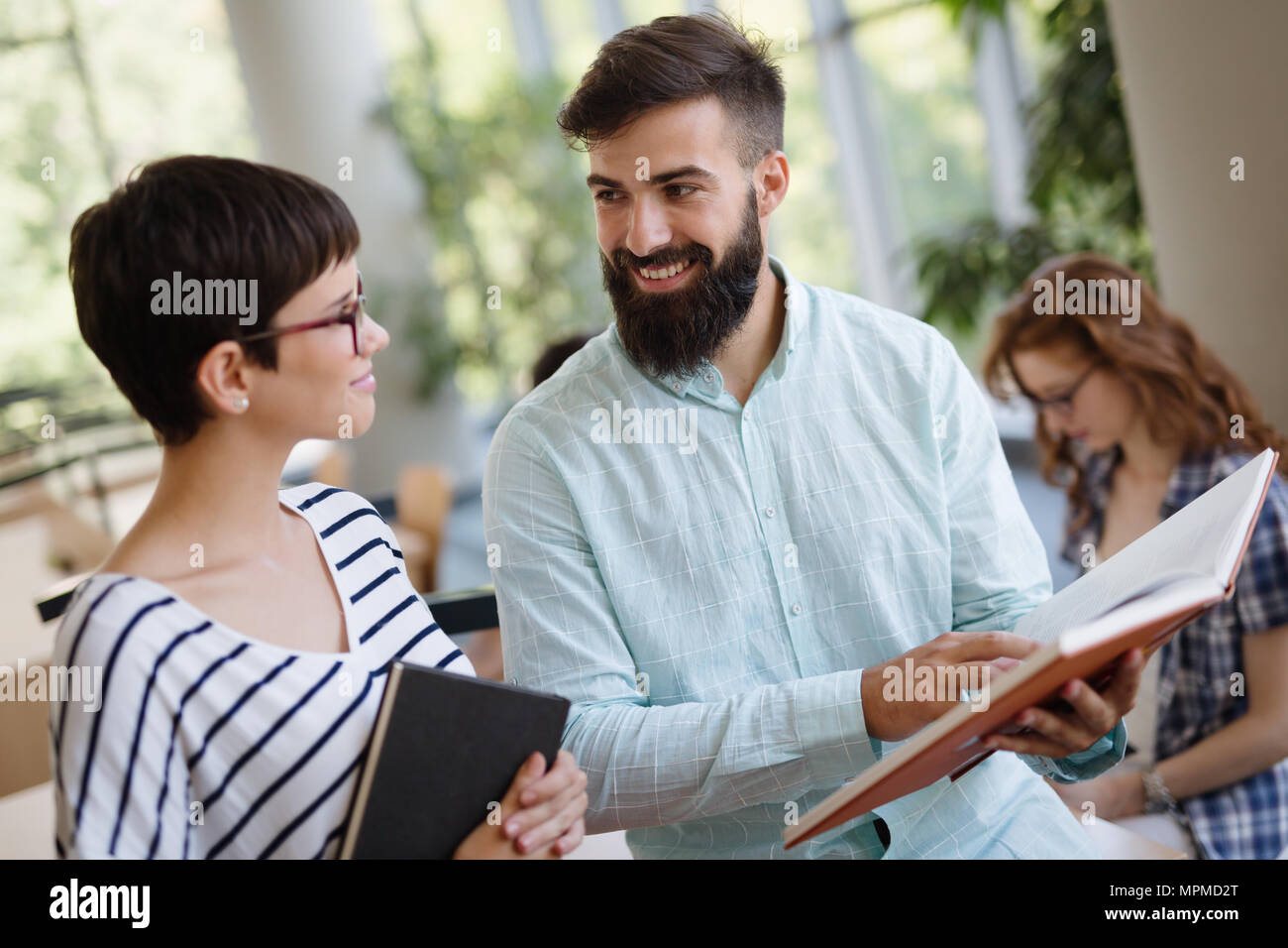 Happy students couple in school library have discussion Stock Photo - Alamy