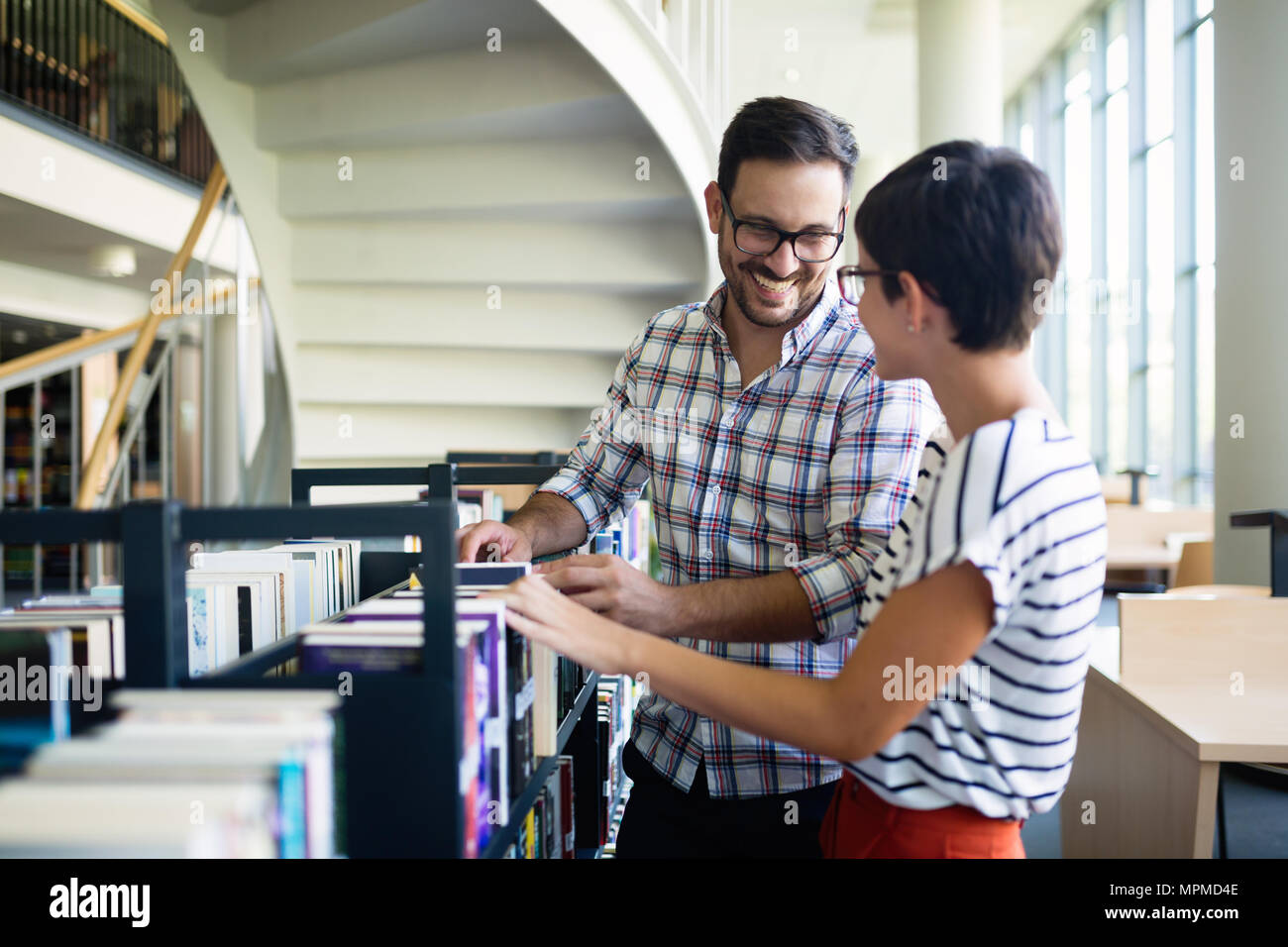 Happy students couple in school library have discussion Stock Photo - Alamy