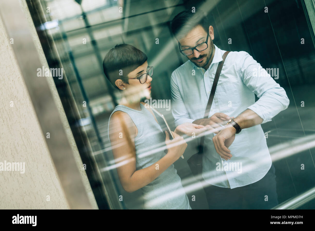 Picture of young businesspeople talking in elevator Stock Photo - Alamy