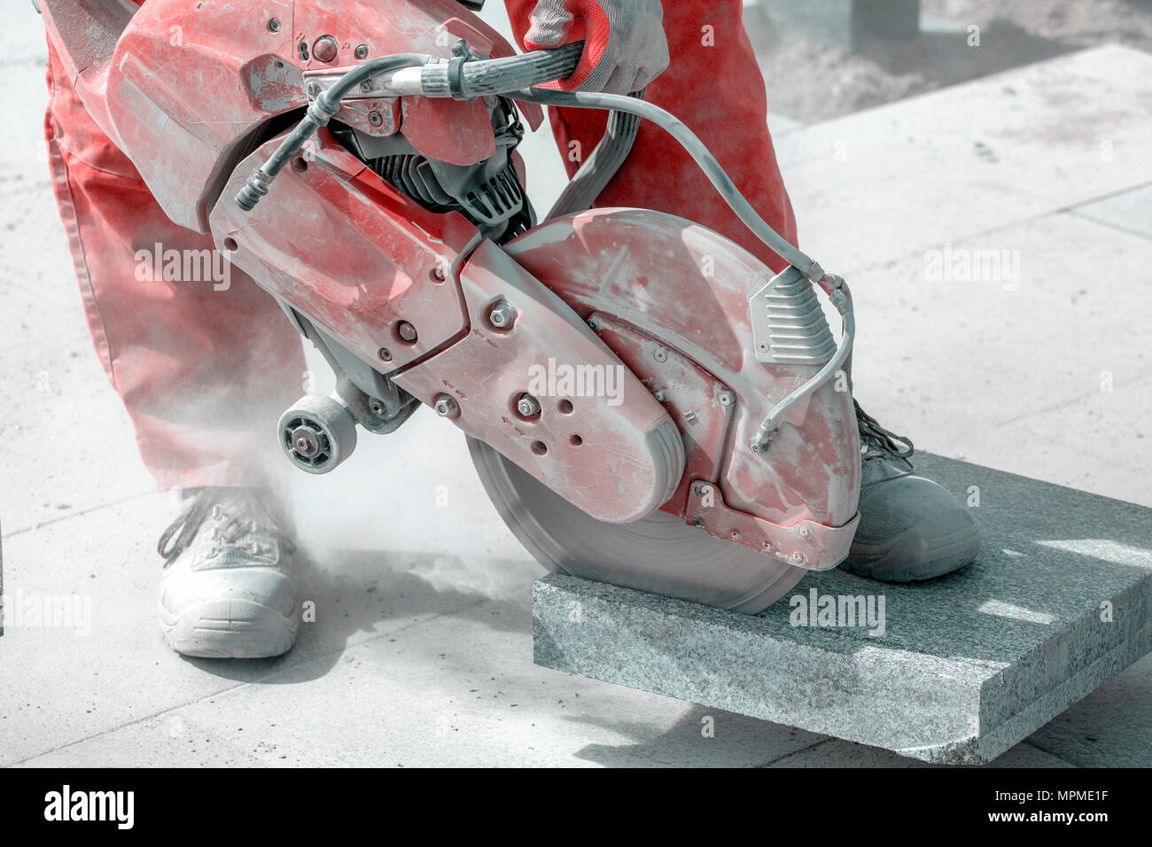 Worker cutting marble tile with electric hand saw at construction site ...