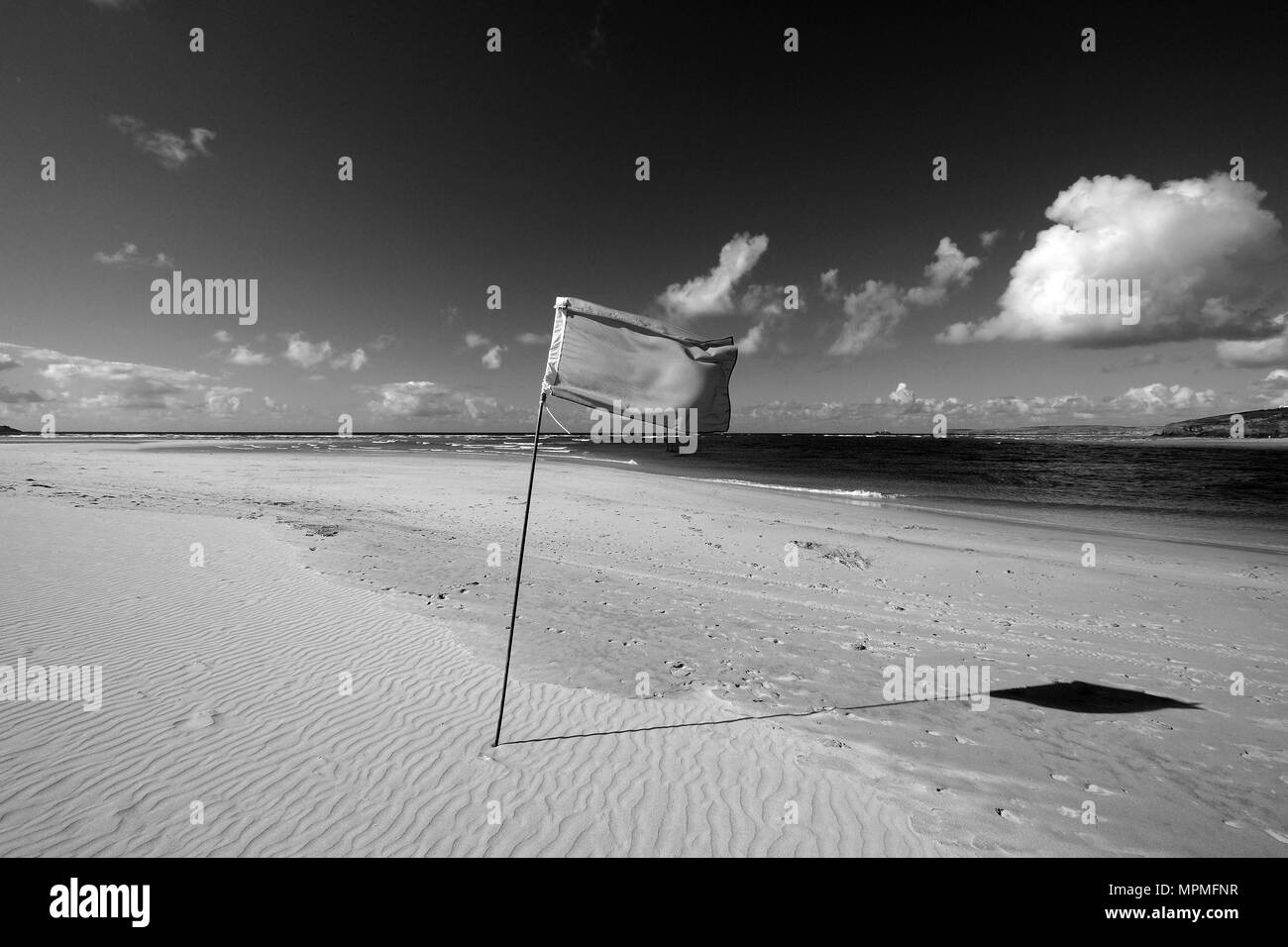 Red & Yellow RNLI Safety Flags on the beach with cloudy blue skies ...