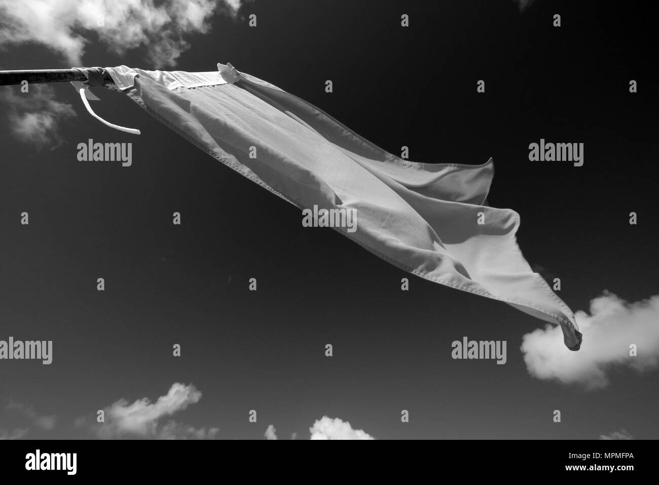 Red & Yellow RNLI Safety Flags on the beach with cloudy blue skies ...