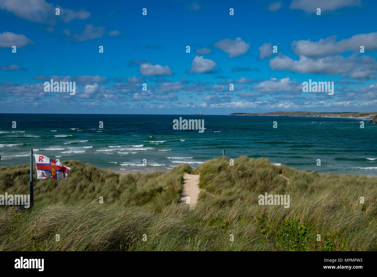 Red & Yellow RNLI Safety Flags on the beach with cloudy blue skies ...