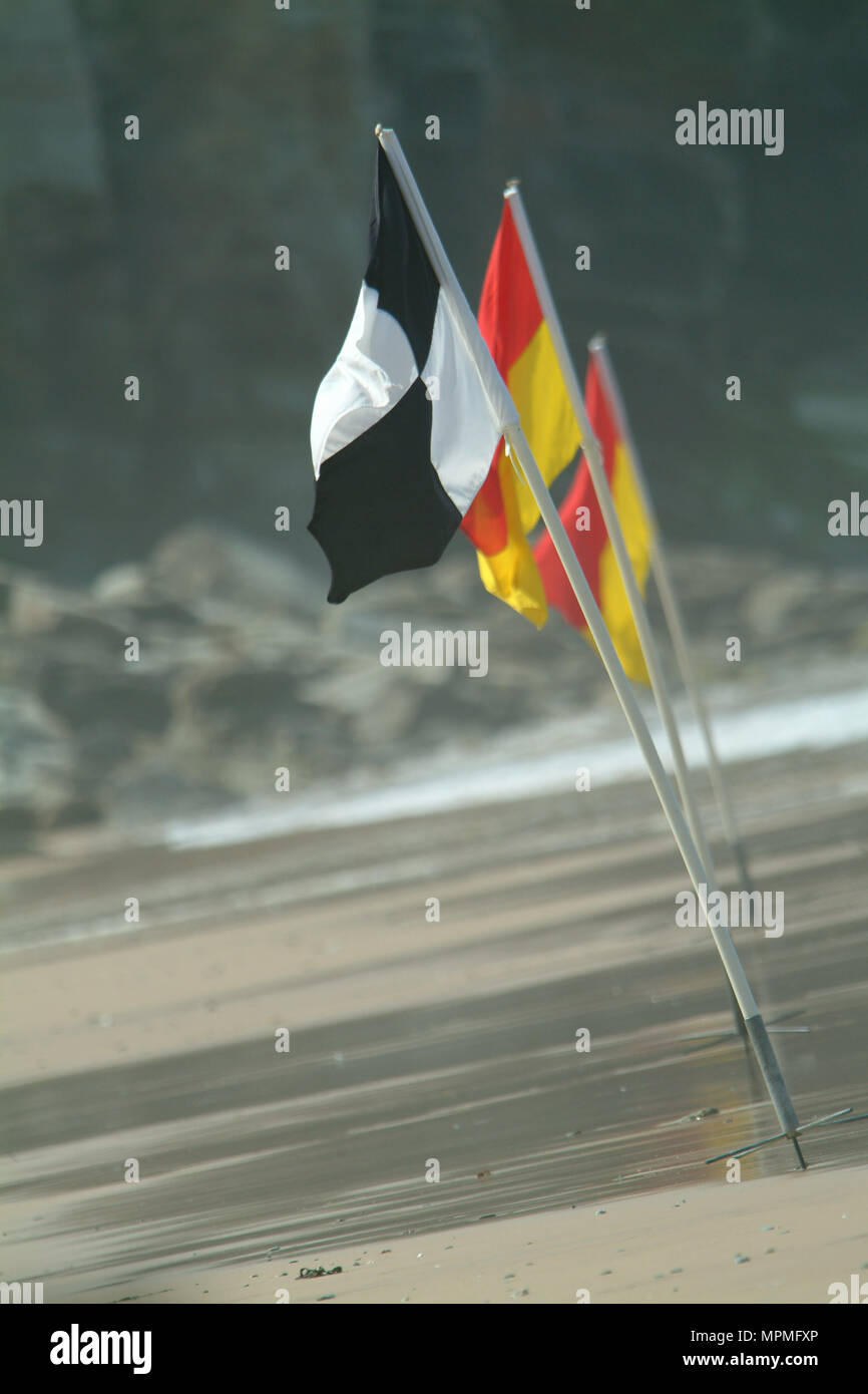 Red & Yellow RNLI Safety Flags on the beach with cloudy blue skies ...