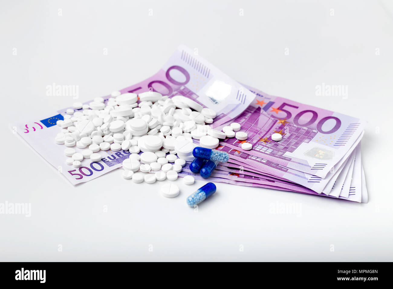 Bunch of white tablets with banknotes.Pharmaceutical business ...