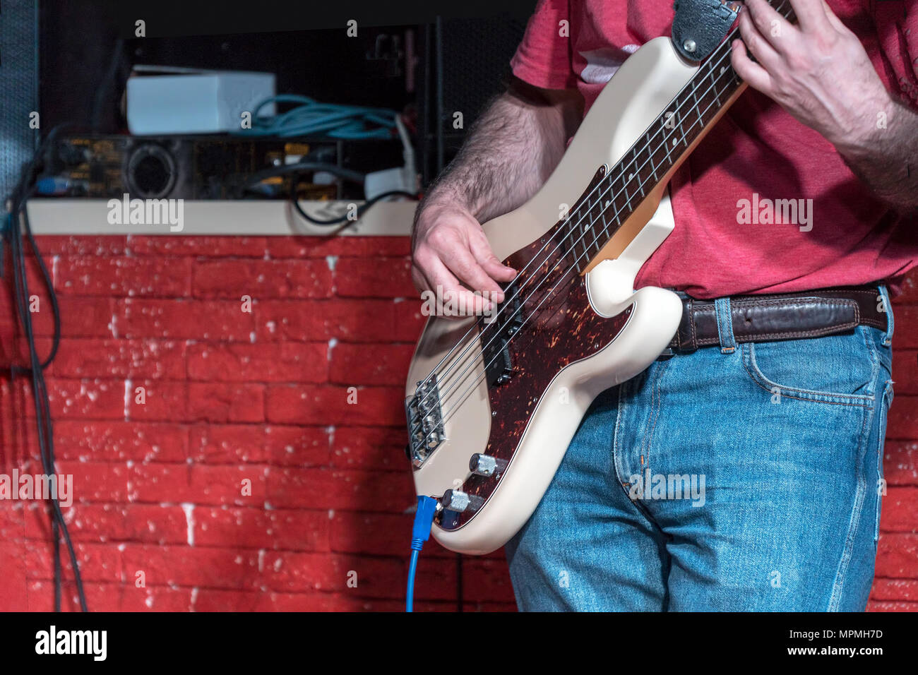 Bass player in jeans with white guitars Stock Photo - Alamy