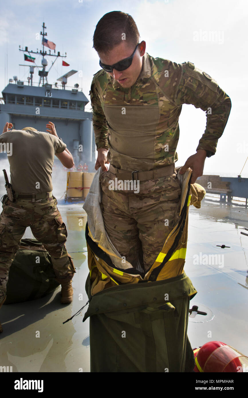 A Soldier with the 481st Transportation Detachment dons bunker gear to ...