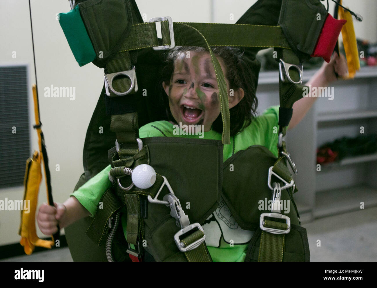 A child of 3d Reconnaissance battalion, 3d Marine Division, is strapped ...