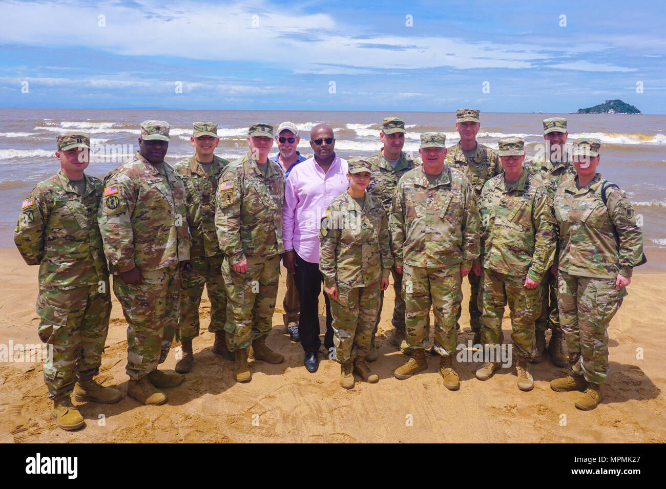 U.S. Army soldiers and civilians pose for a group photo on the shore of ...