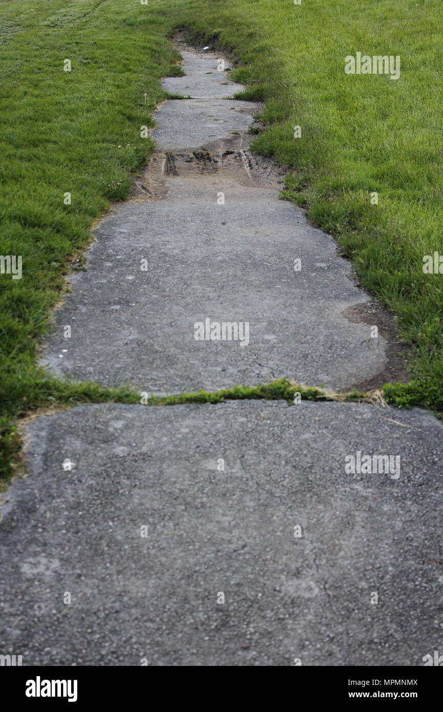 Paved walking path to nowhere and the end of the road signifying the ...