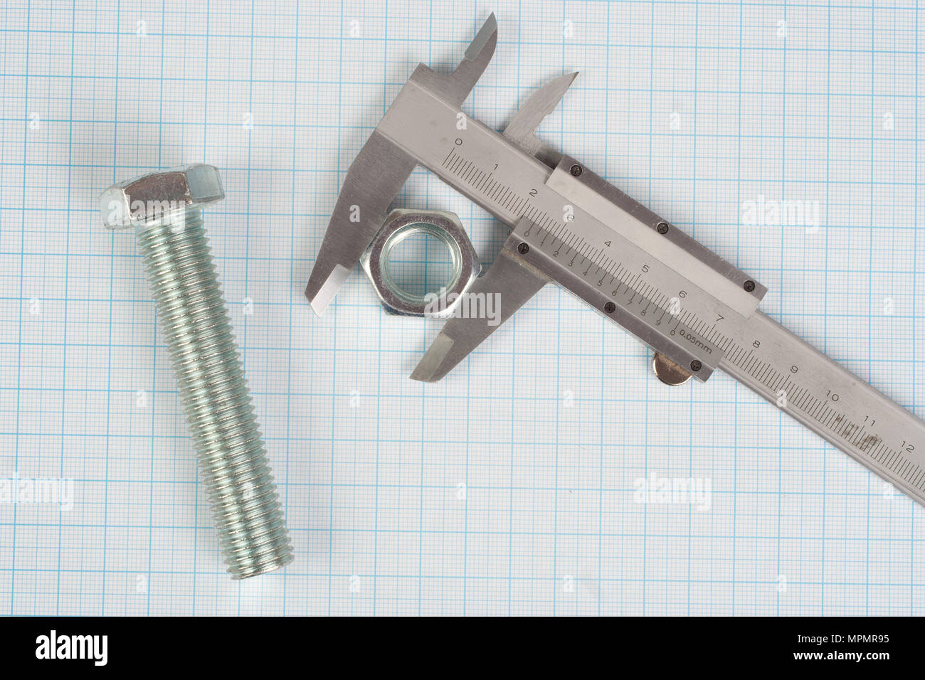 Screw, Nuts and caliper on graph paper background Stock Photo - Alamy