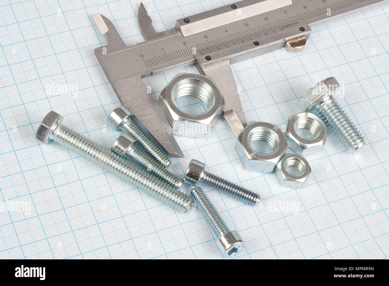 Screw, Nuts and caliper on graph paper background Stock Photo - Alamy