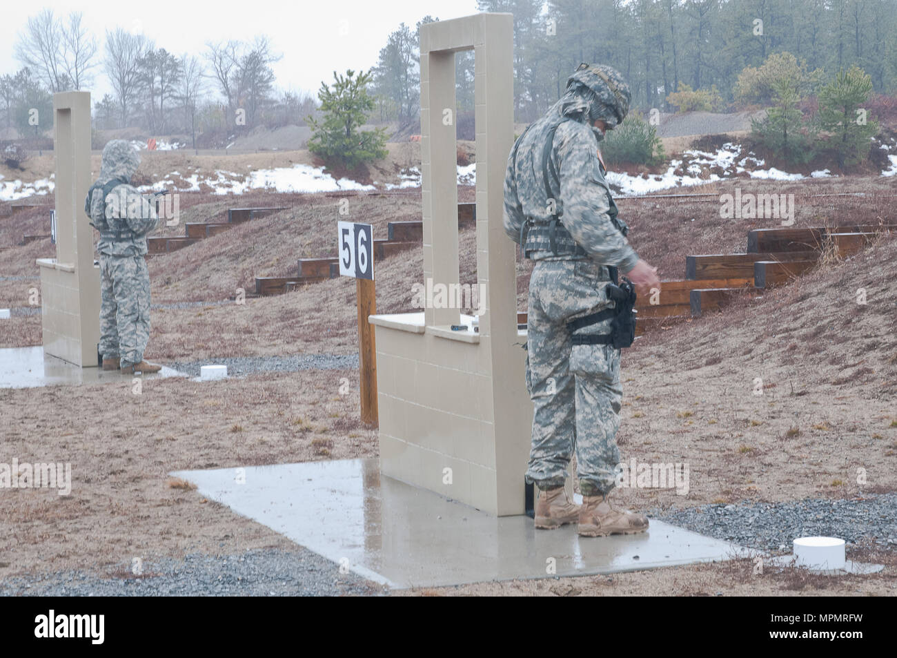 Soldiers stand ready to engage targetsat the M9 pistol marksmanship ...
