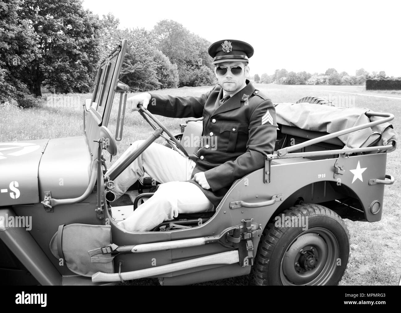 Handsome American WWII GI Army officer in uniform riding Willy Jeep ...
