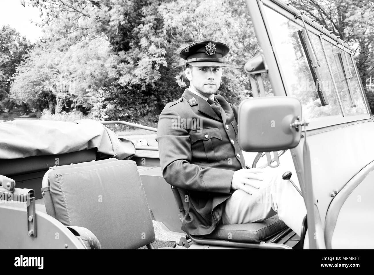 Handsome American WWII GI Army officer in uniform riding Willy Jeep ...
