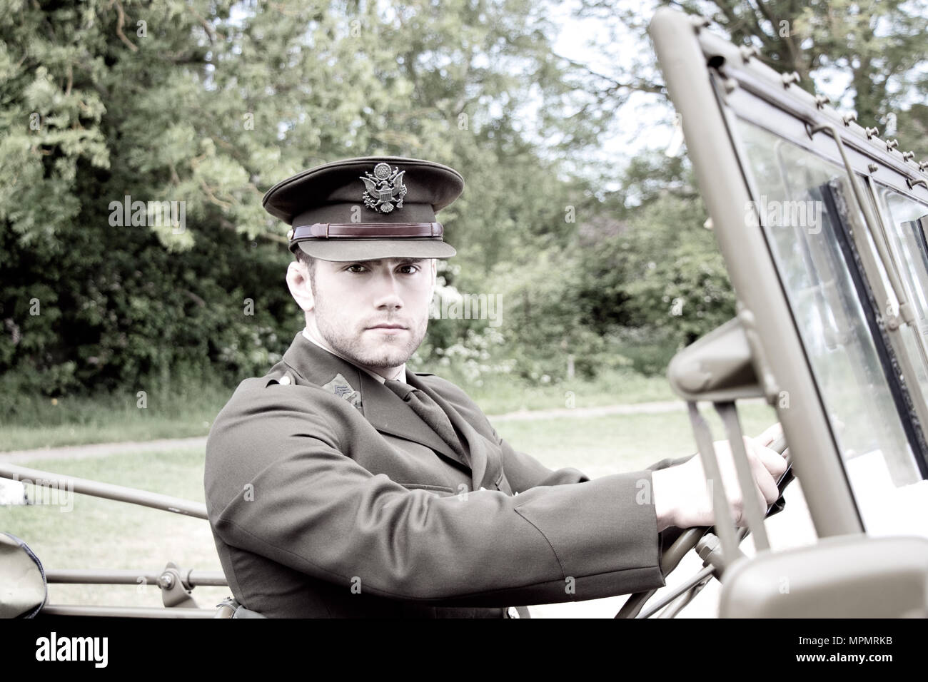 Handsome American WWII GI Army officer in uniform riding Willy Jeep ...