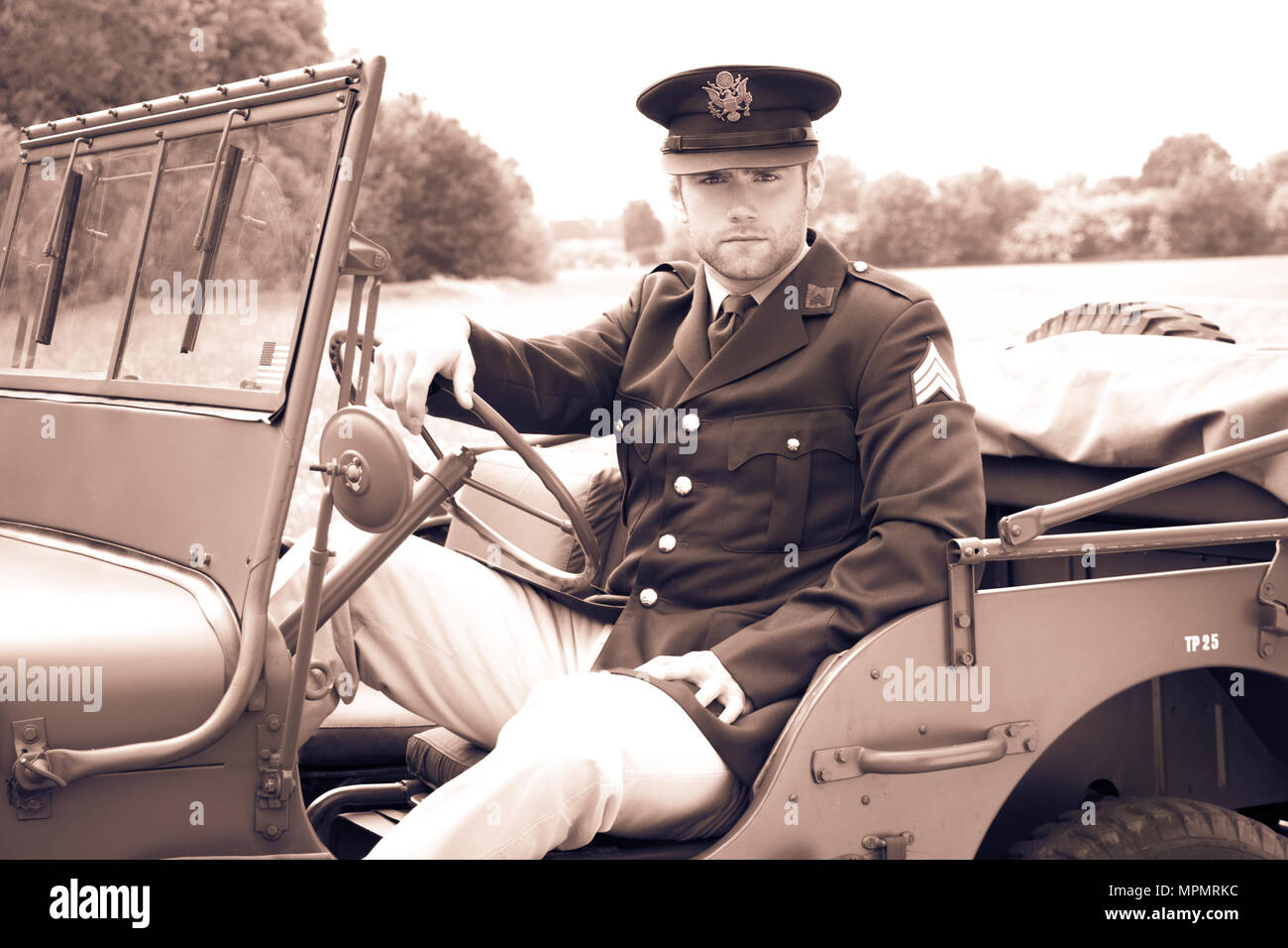 Handsome American WWII GI Army officer in uniform riding Willy Jeep ...