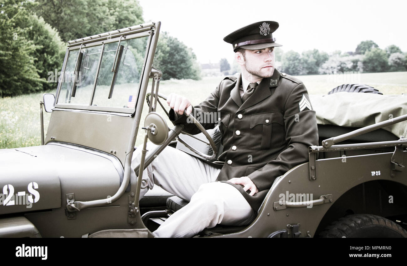 Handsome American WWII GI Army officer in uniform riding Willy Jeep ...