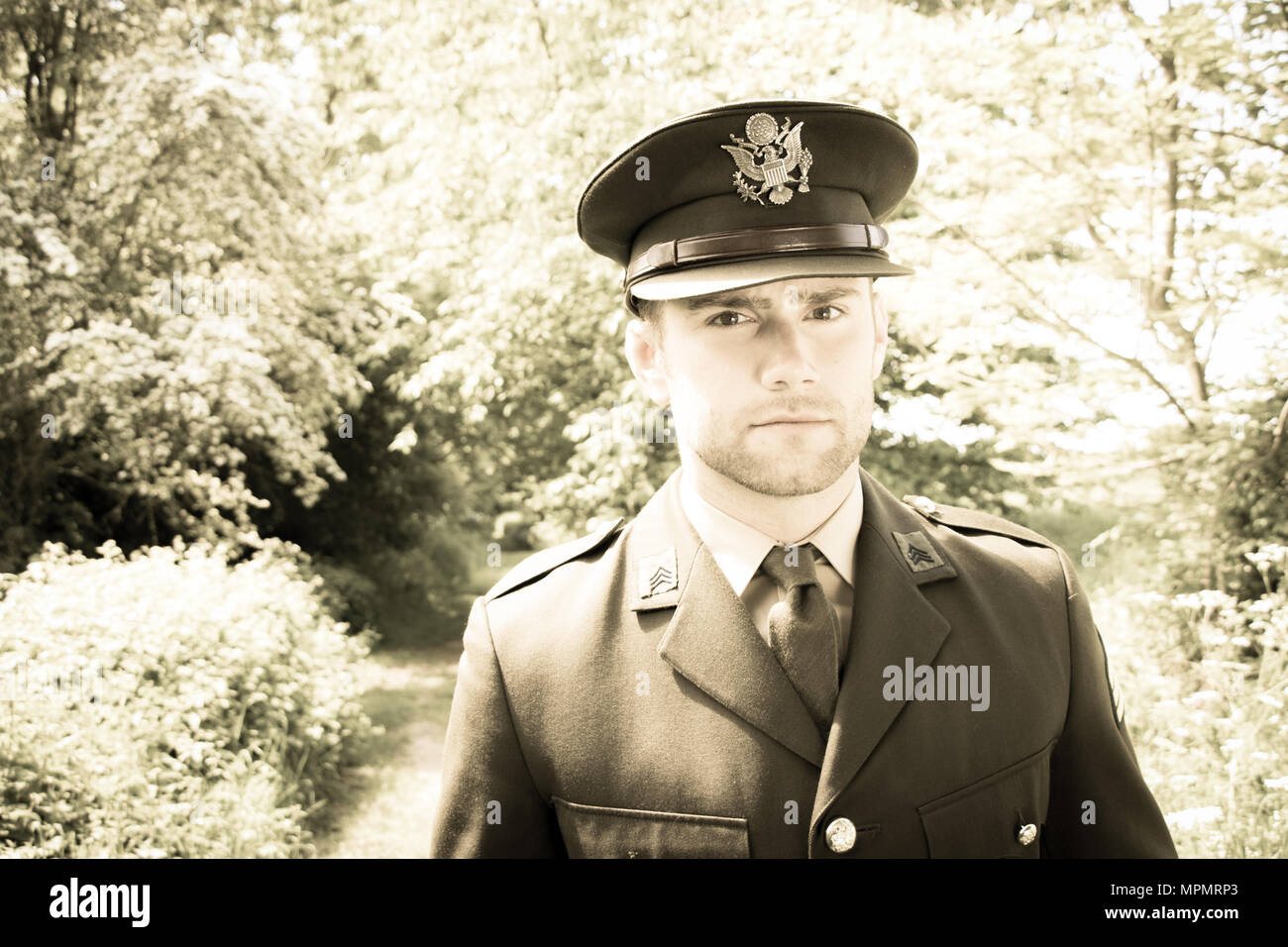 Handsome American WWII GI Army officer in uniform walking through woods ...